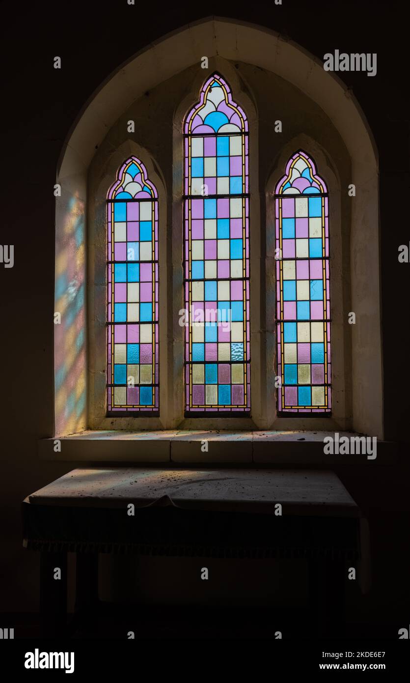 Light shining through stained glass window of small chapel with dark ...