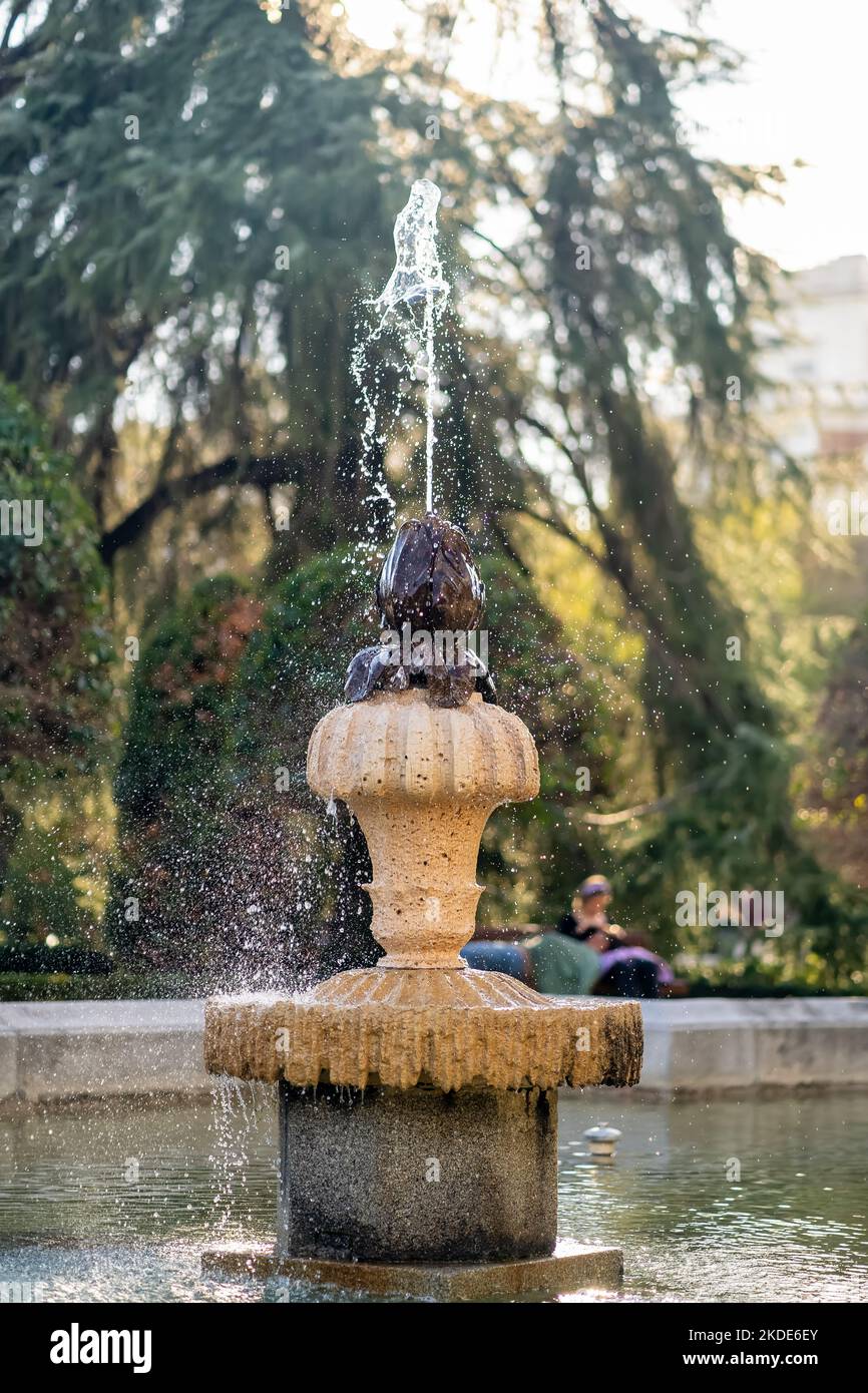 Old fountain of a park throwing jets of water with sunlight behind, El ...