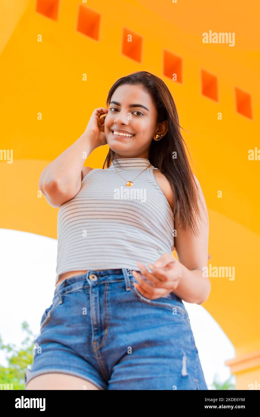 Portrait of attractive Latin girl outdoors. Smiling latin young woman looking at camera outdoors ...