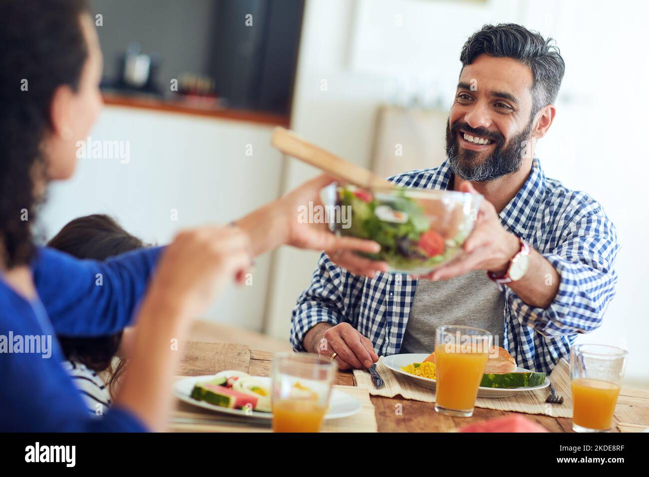 Teaching table manners by example. a happy family gathered around their ...
