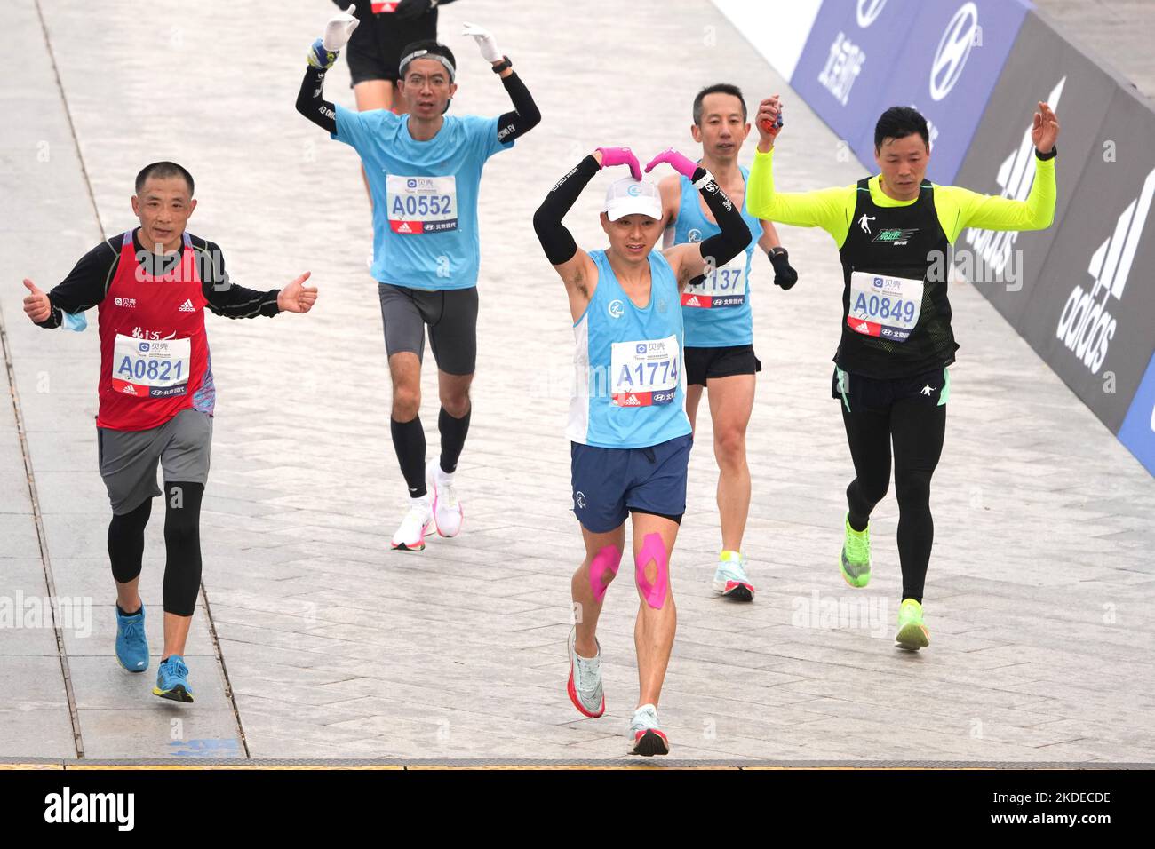 Beijing, China. 6th Nov, 2022. Runners pose as they cross the finish ...