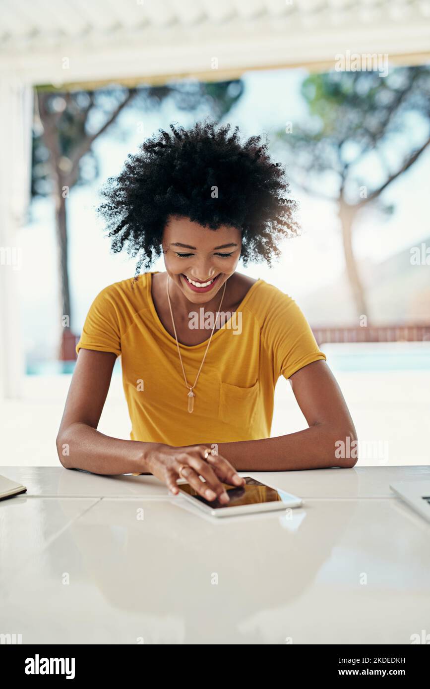 Doing what she loves. an attractive young woman using her laptop while ...