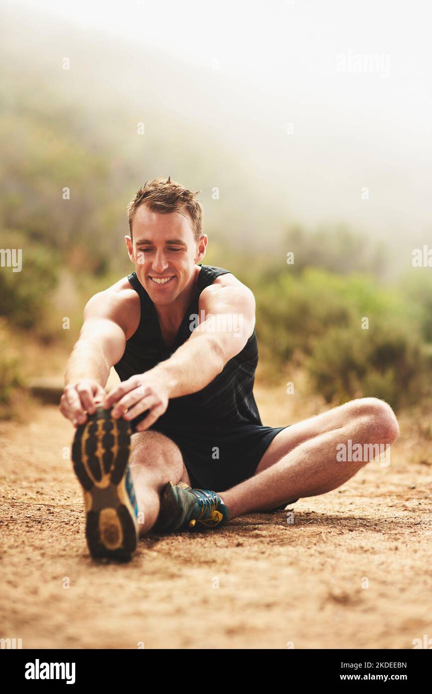Always start with a warmup. a sporty young man stretching before a run ...