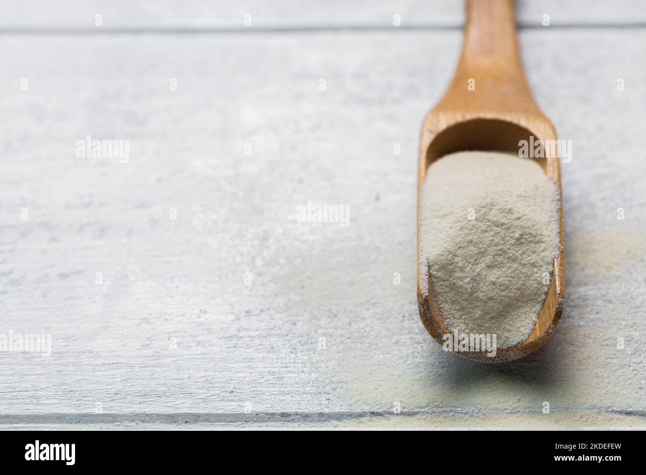 Collagen powder in spoon on wooden white background. Extra protein ...