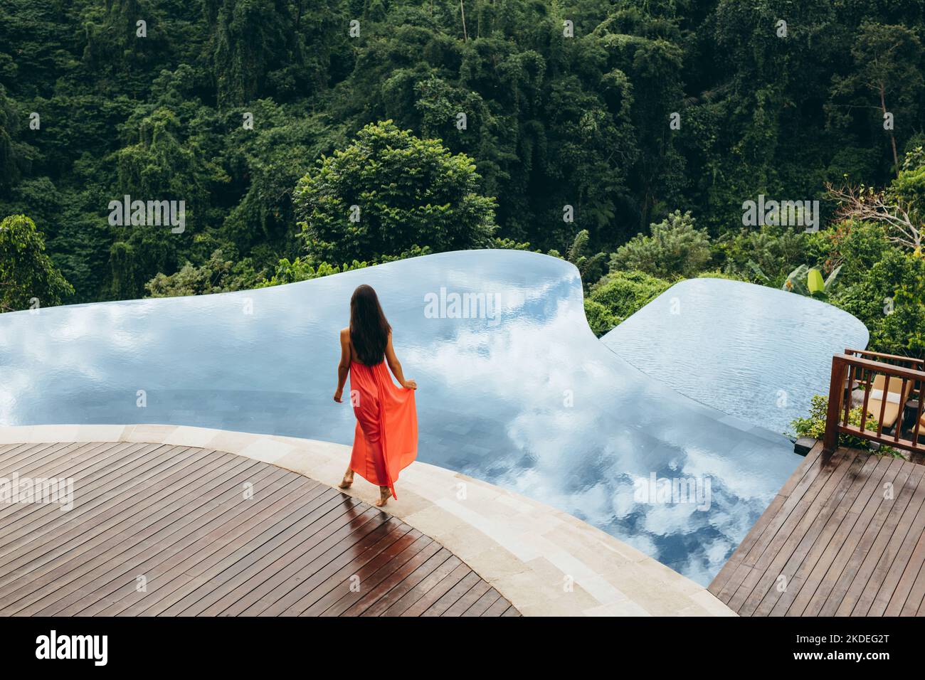 Shot of relaxed young woman walking near poolside of holiday resort ...