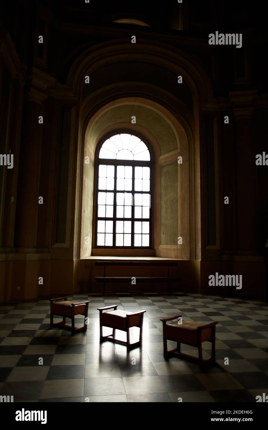 The interior is a vintage hall with a high ceiling and a huge window ...