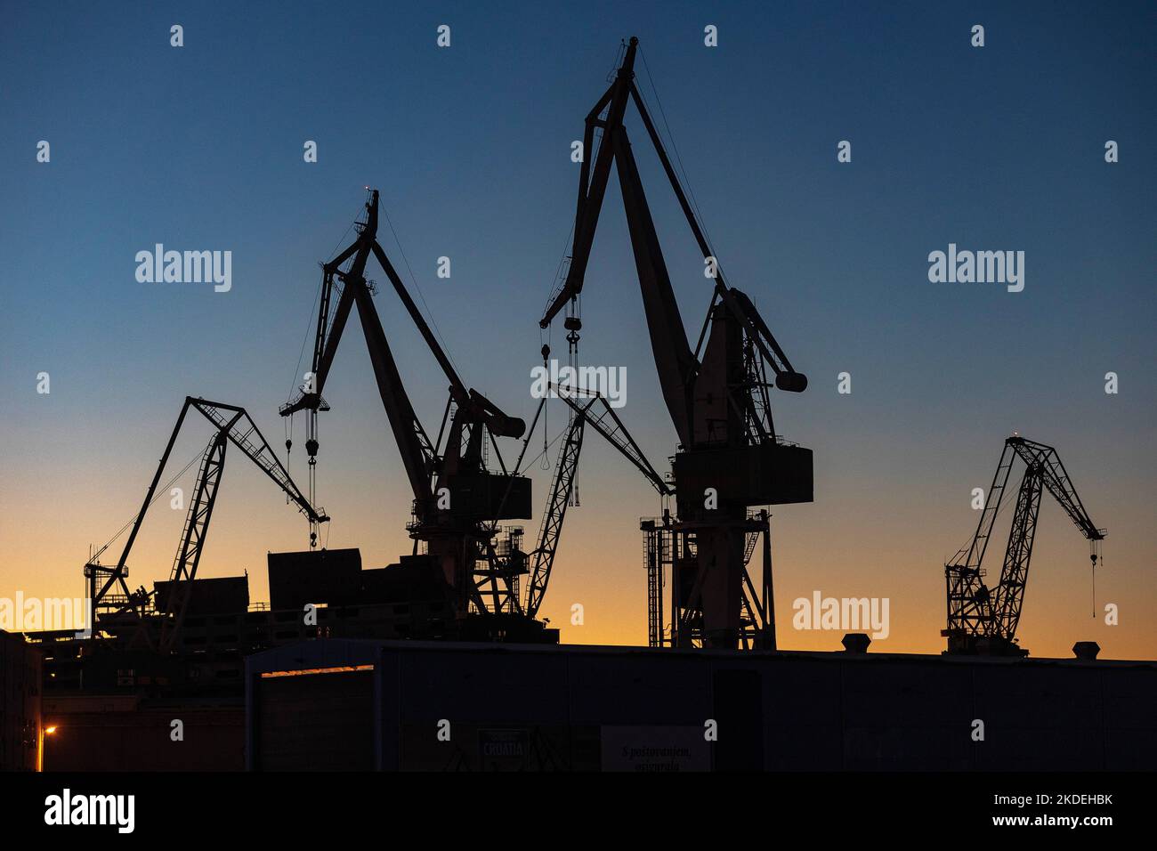 A crane silhouette is pictured as sun sets at Pula port in Pula ...