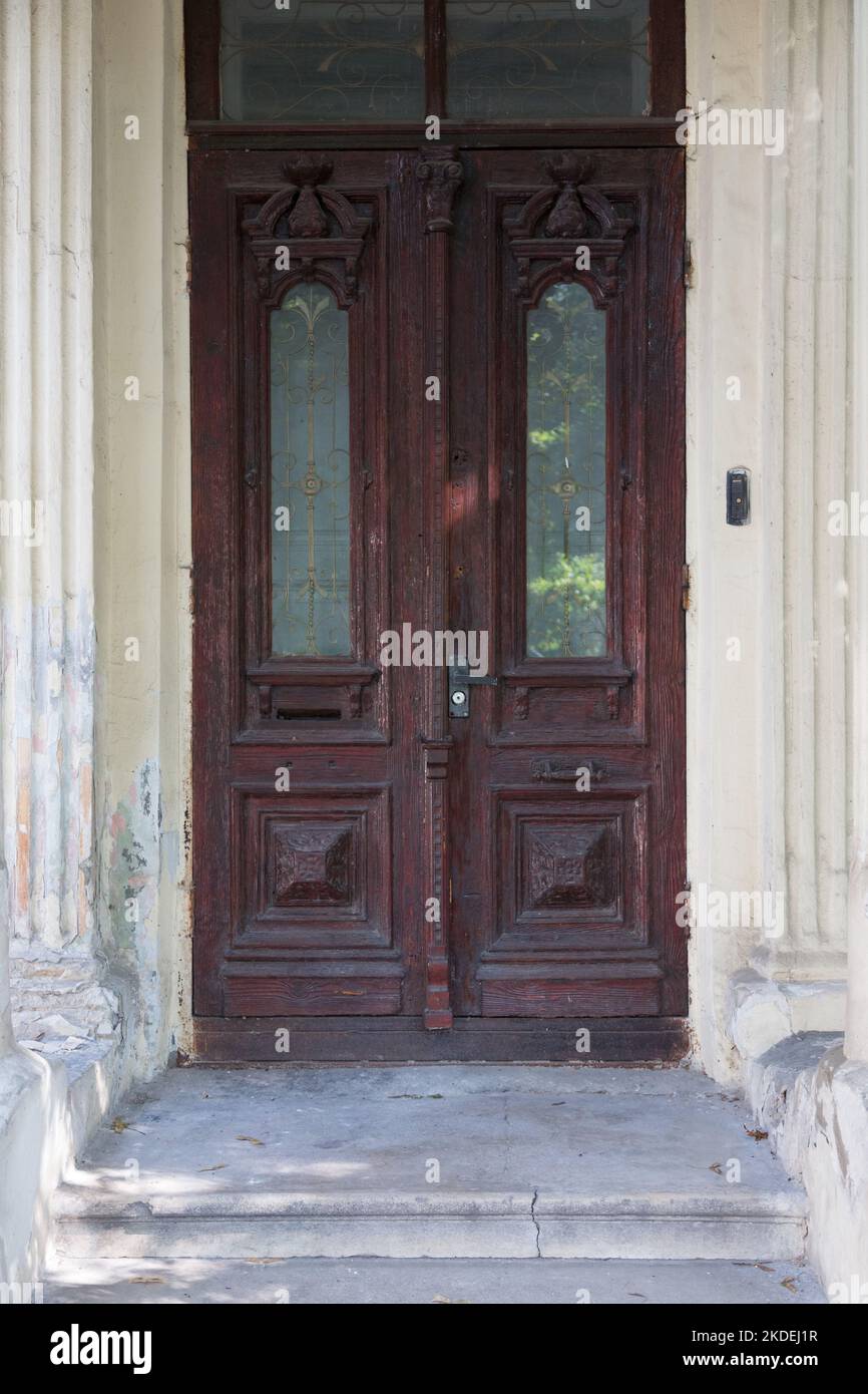 One old brown door made of wood and glass. Entrance to the old building ...