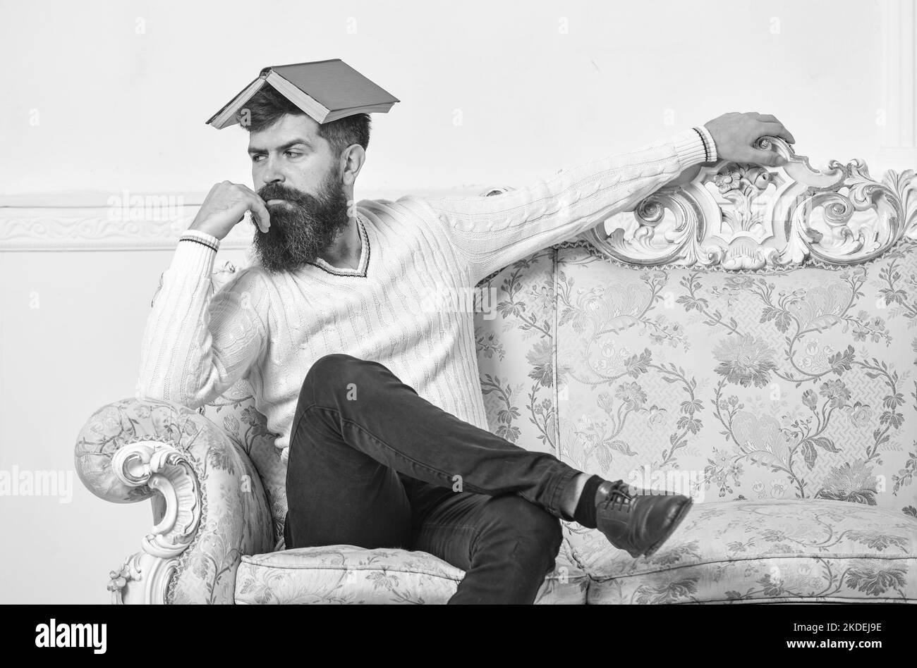 Macho sits with open book on head, like roof. Boring literature concept ...