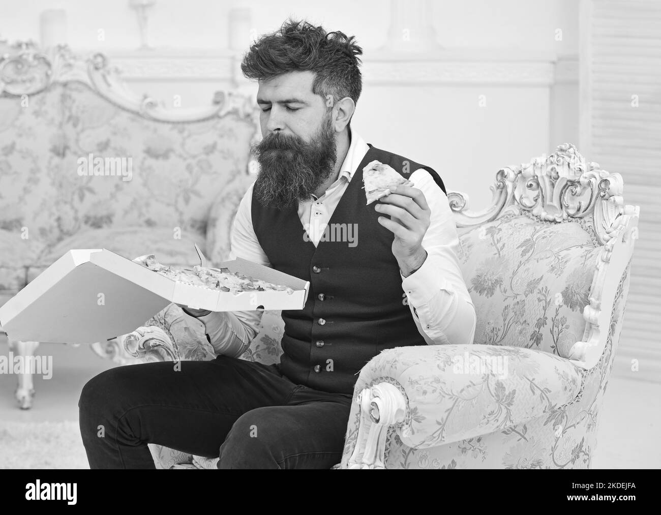 Macho in classic clothes hungry, holds slice of cheese pizza, eats ...