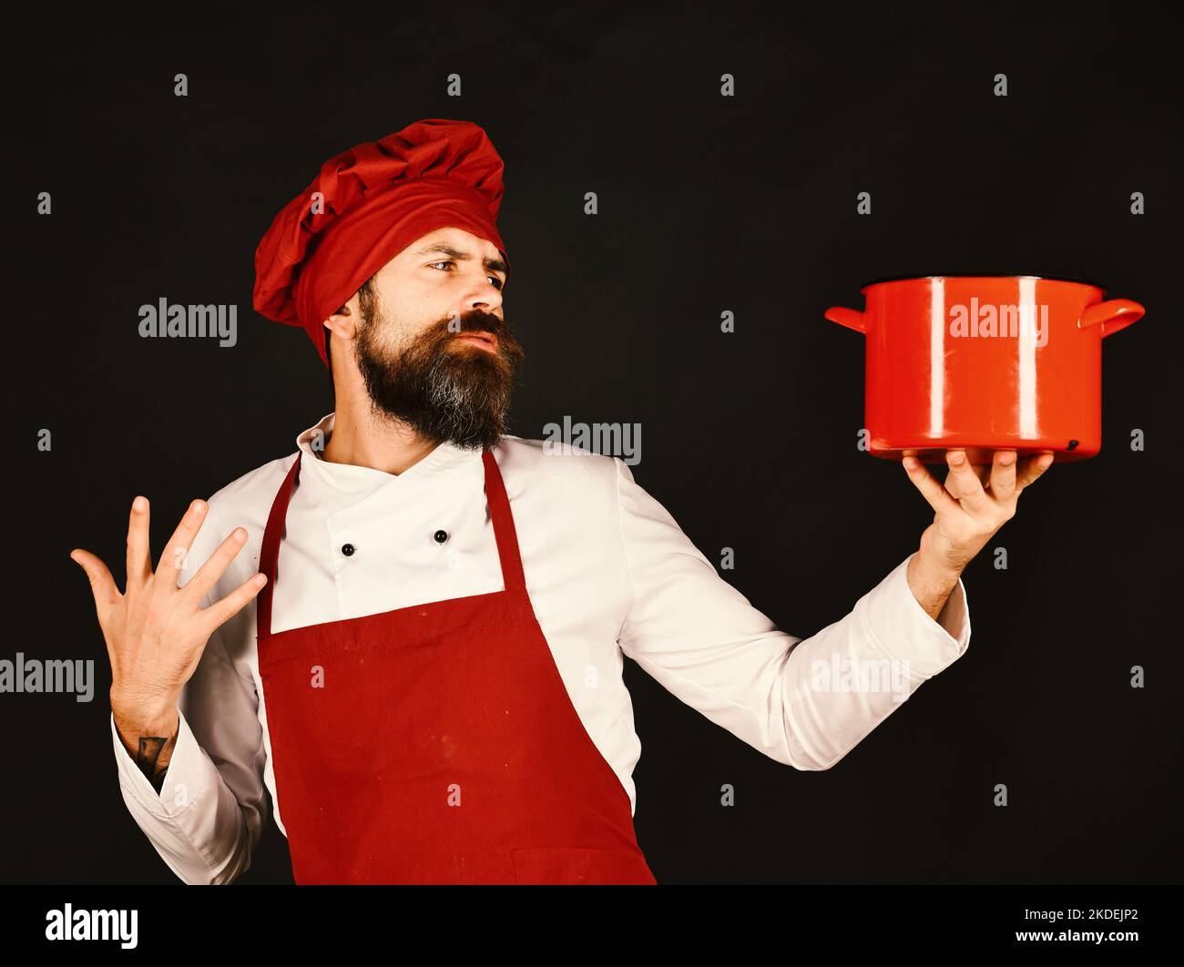 Cooking process concept. Chef with red casserole or saucepan Stock ...