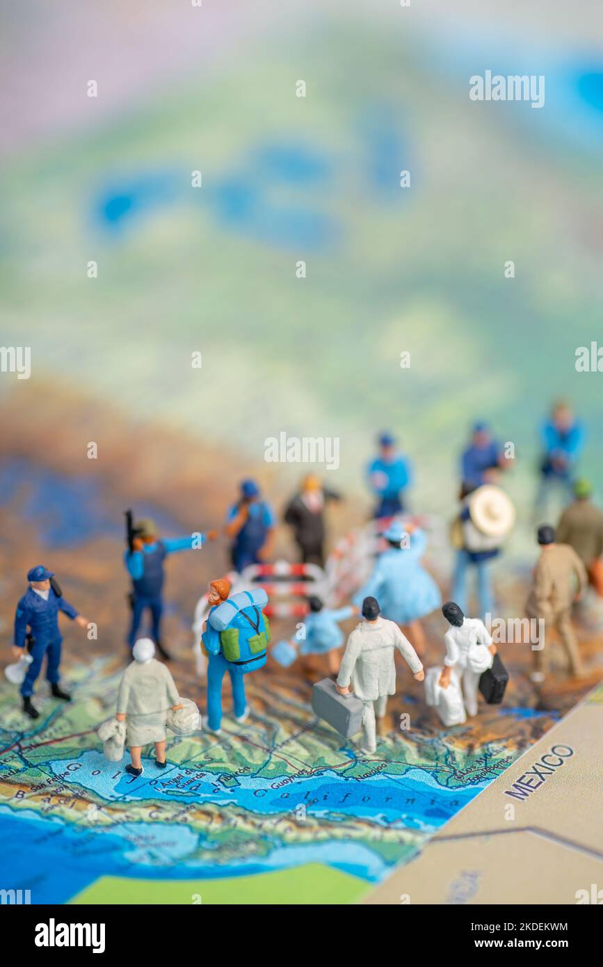 Miniature toy people concept US border patrols against a group of ...