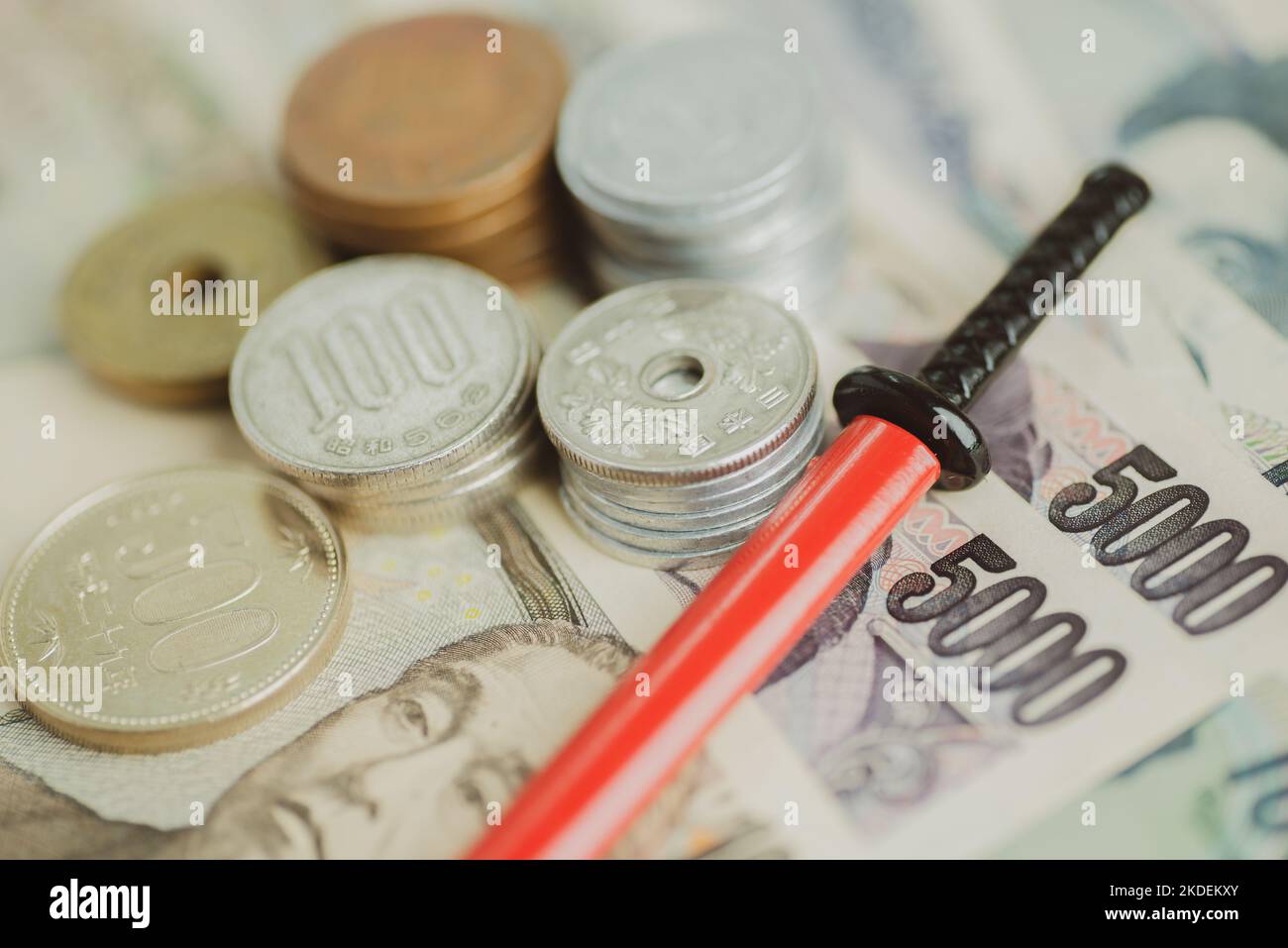 Japanese Yen in notes and coins and a miniature katana in red scabbard ...