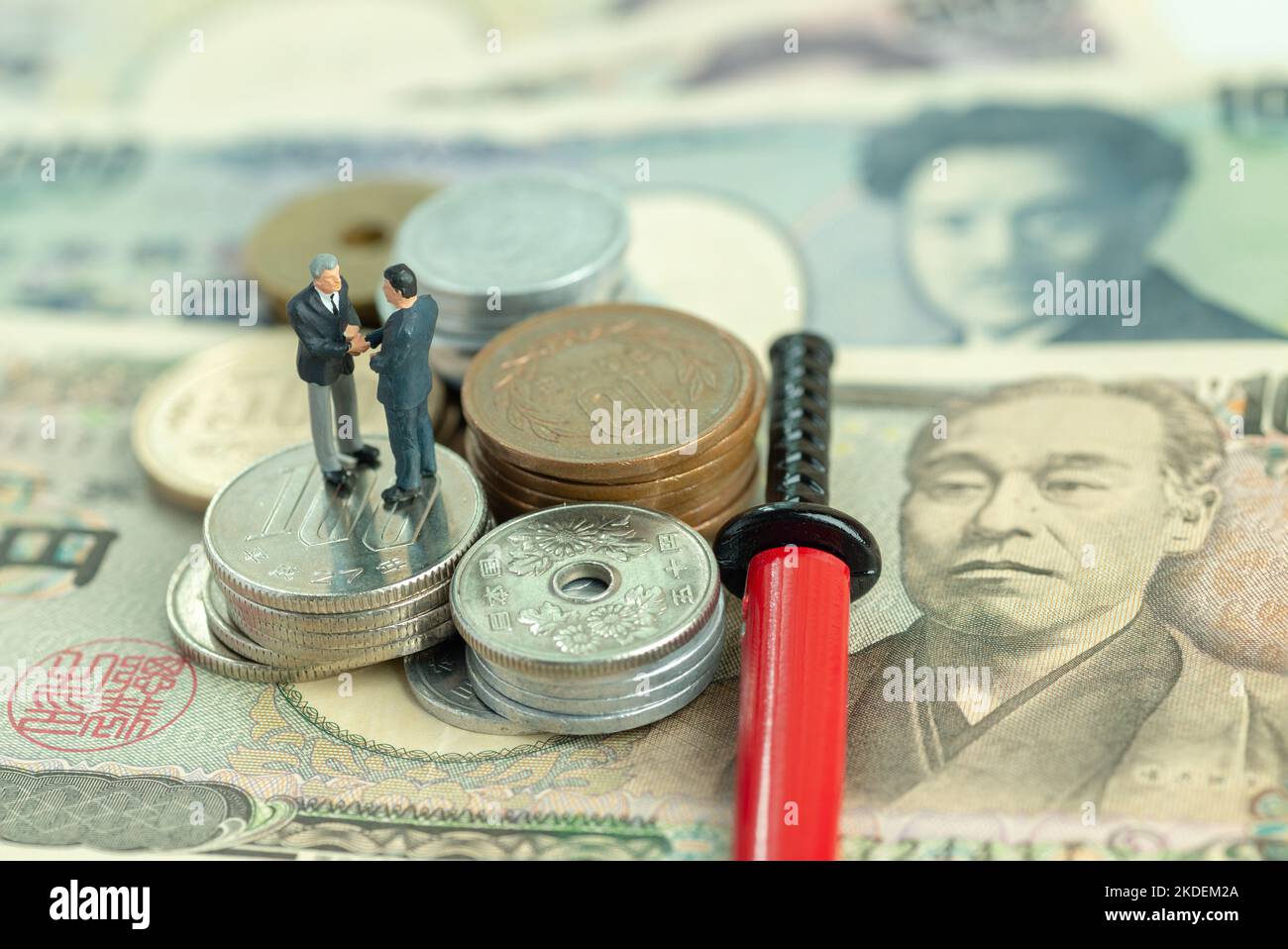 Japanese Yen in notes and coins and a miniature katana in red scabbard ...
