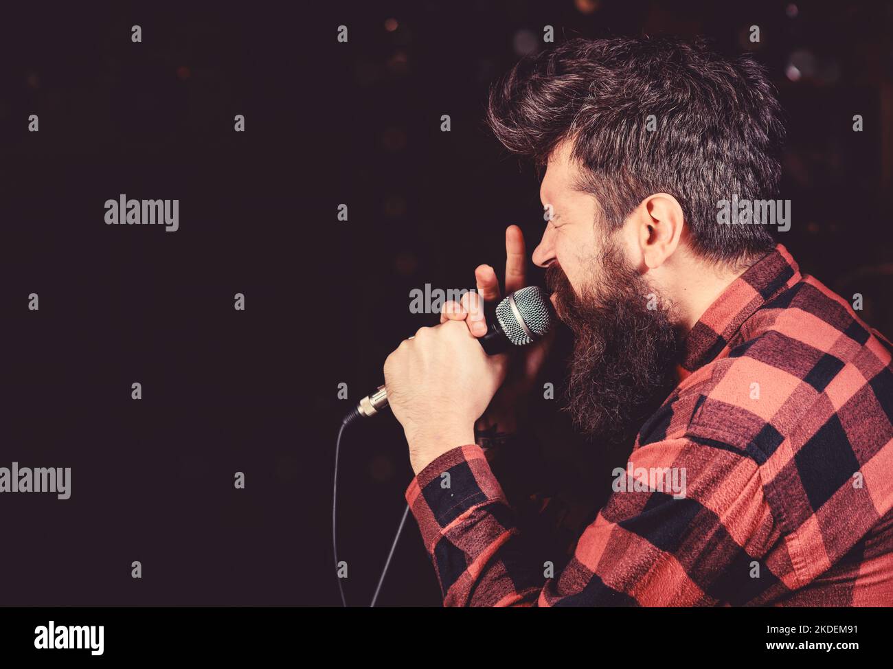 Talented vocalist concept. Man on tense face holds microphone, singing ...