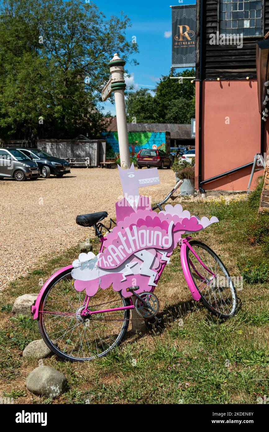 A quirky sign uses a decorated bicycle to advertise the Art Hound ...