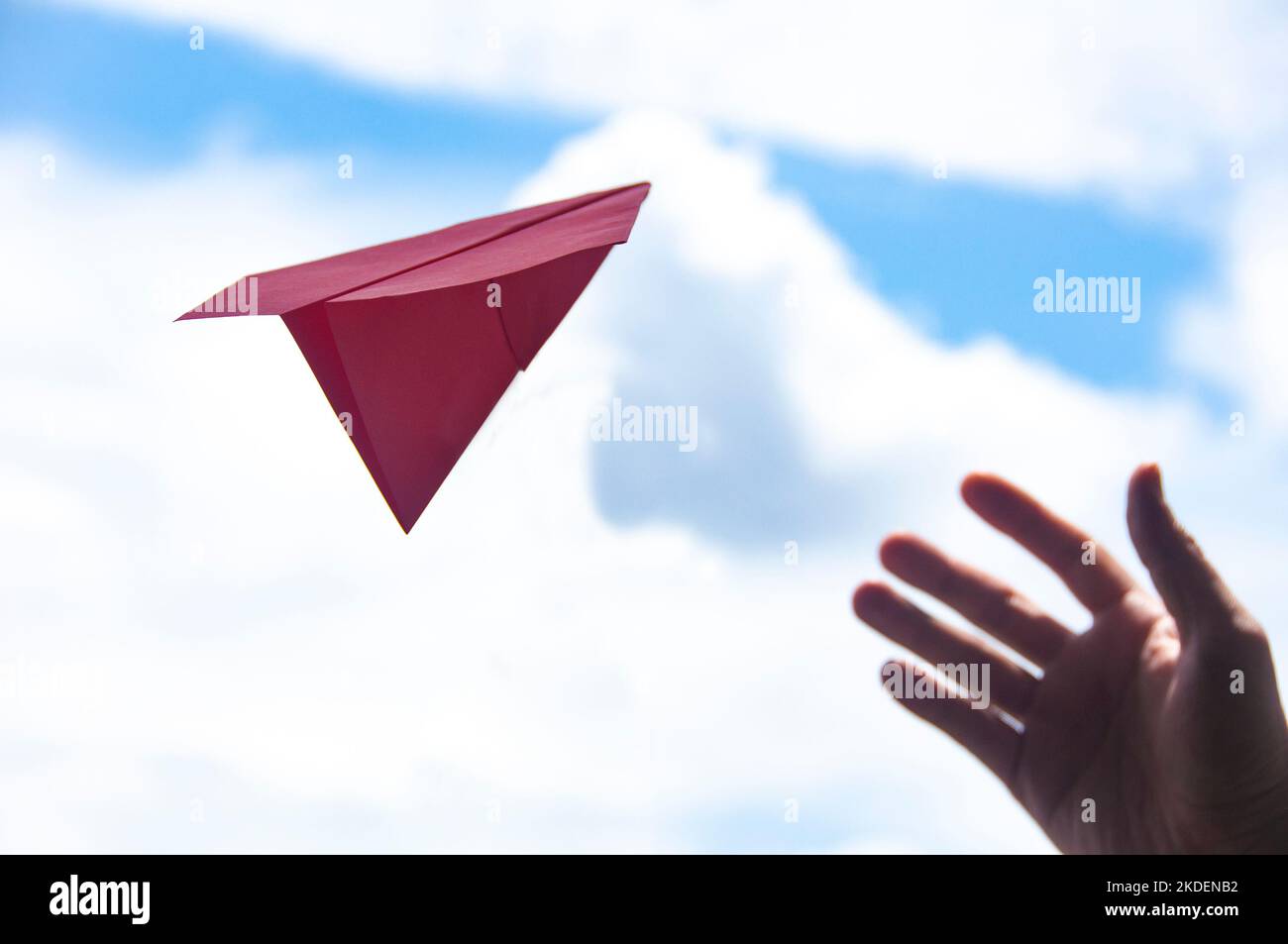 Hand trying to catch flying red paper plane. Travelling concept Stock ...