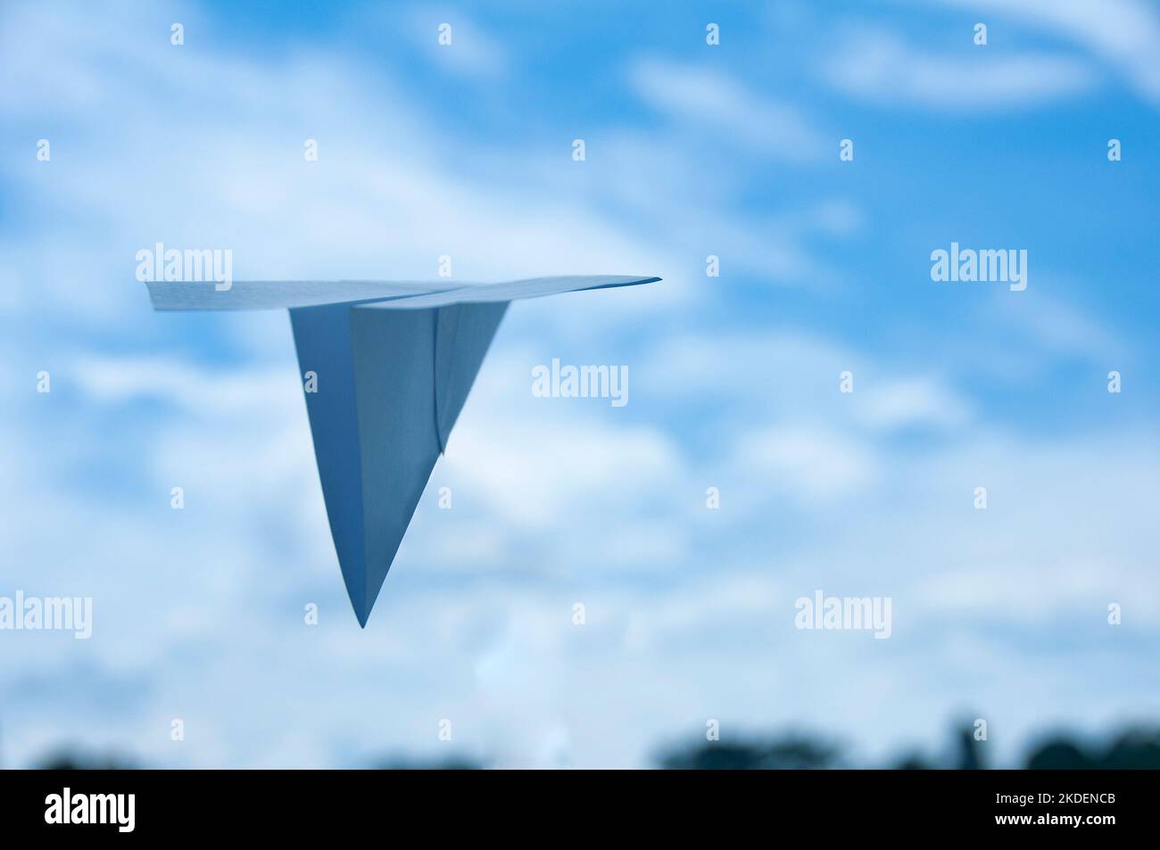 Flying white paper plane on blue sky background Stock Photo - Alamy