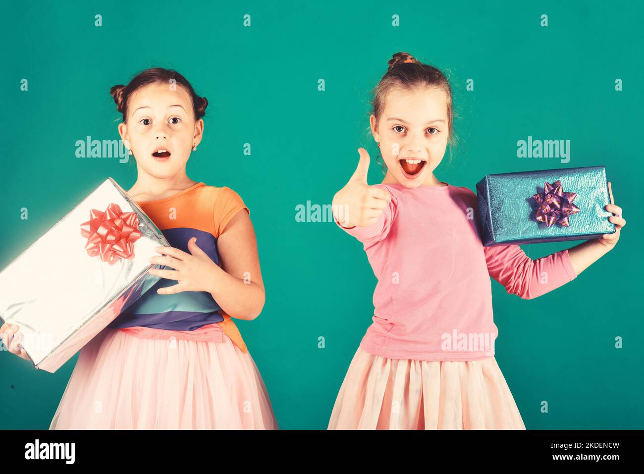 Children with excited faces pose with presents on green background ...