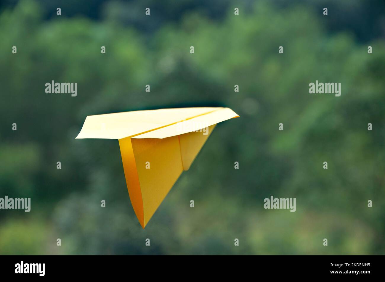 Flying yellow paper plane with nature background view Stock Photo - Alamy