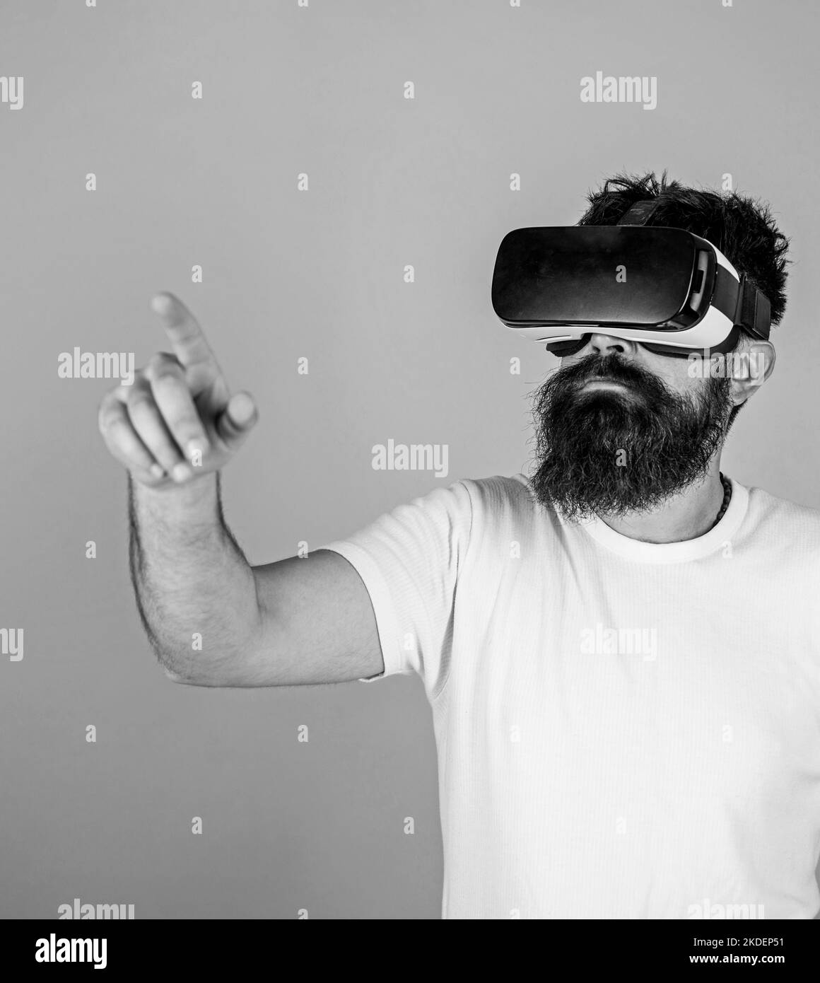 Man with hipster beard in VR glasses using digital touch screen ...