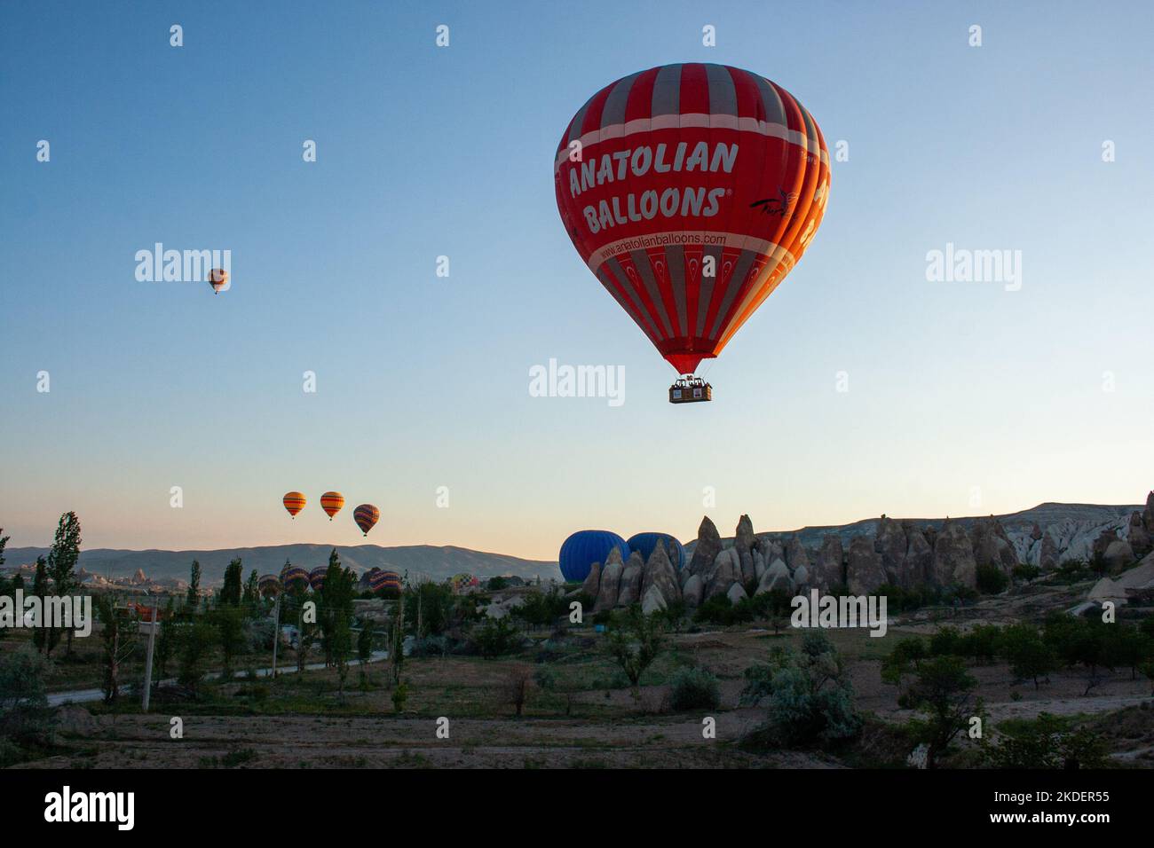 hot air balloons rise over the chimneys rock formation, Cappadocia ...