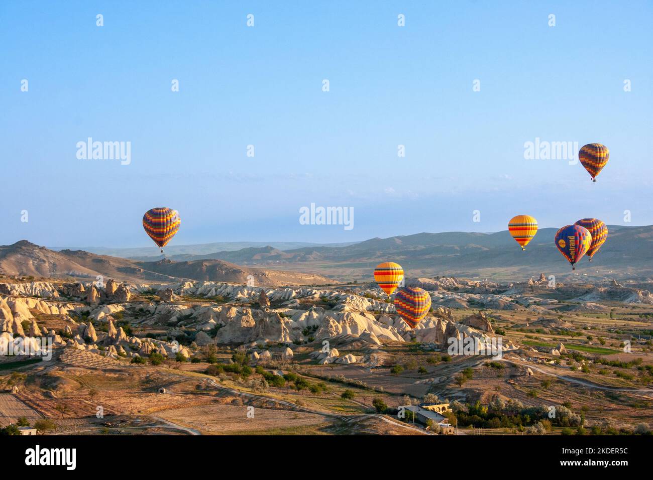hot air balloons rise over the chimneys rock formation, Cappadocia ...