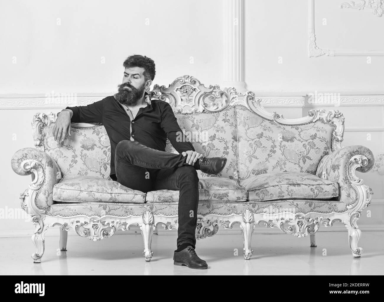 Hipster on arrogant face sits alone. Man with beard and mustache spends ...