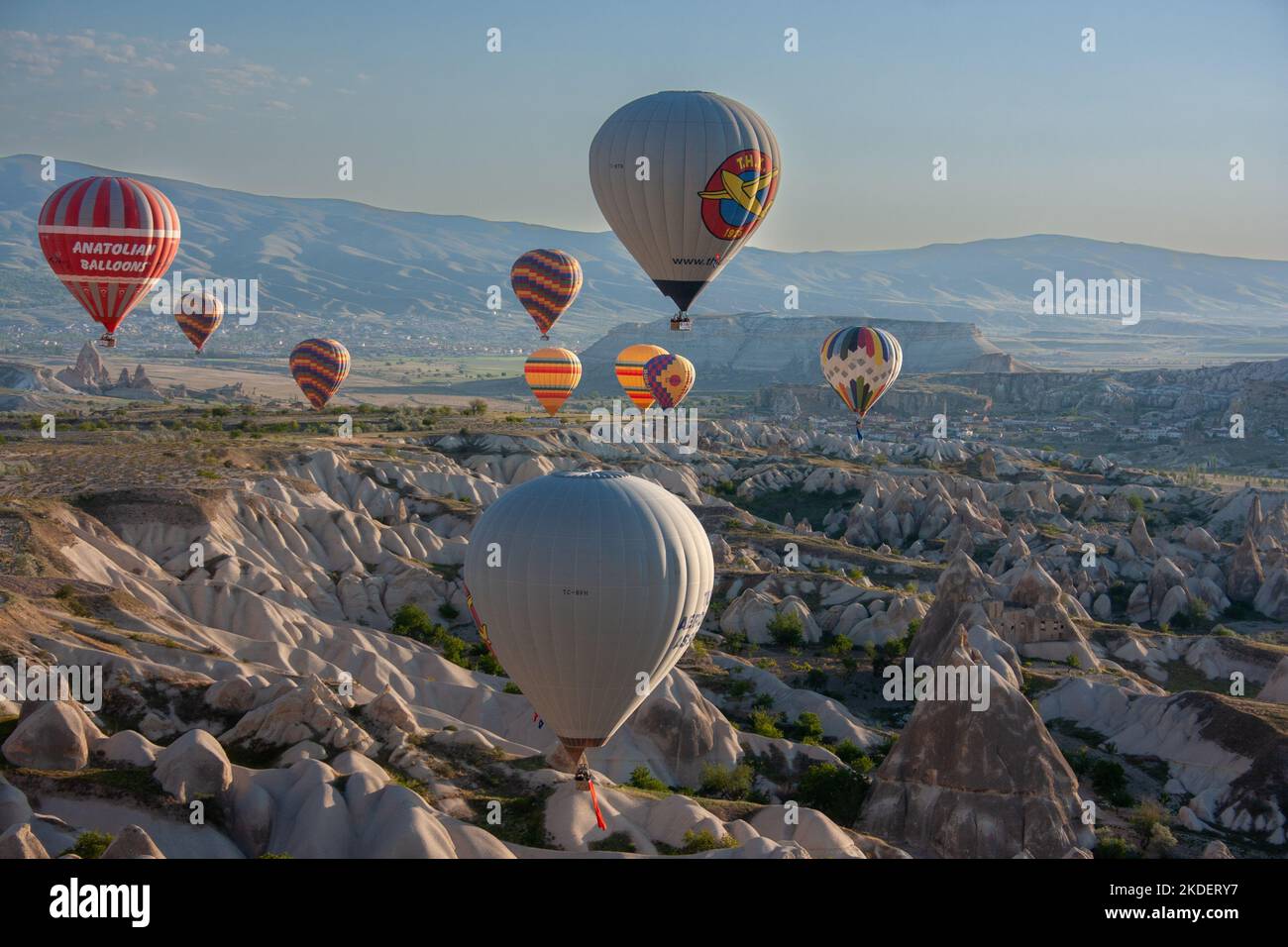 hot air balloons rise over the chimneys rock formation, Cappadocia ...