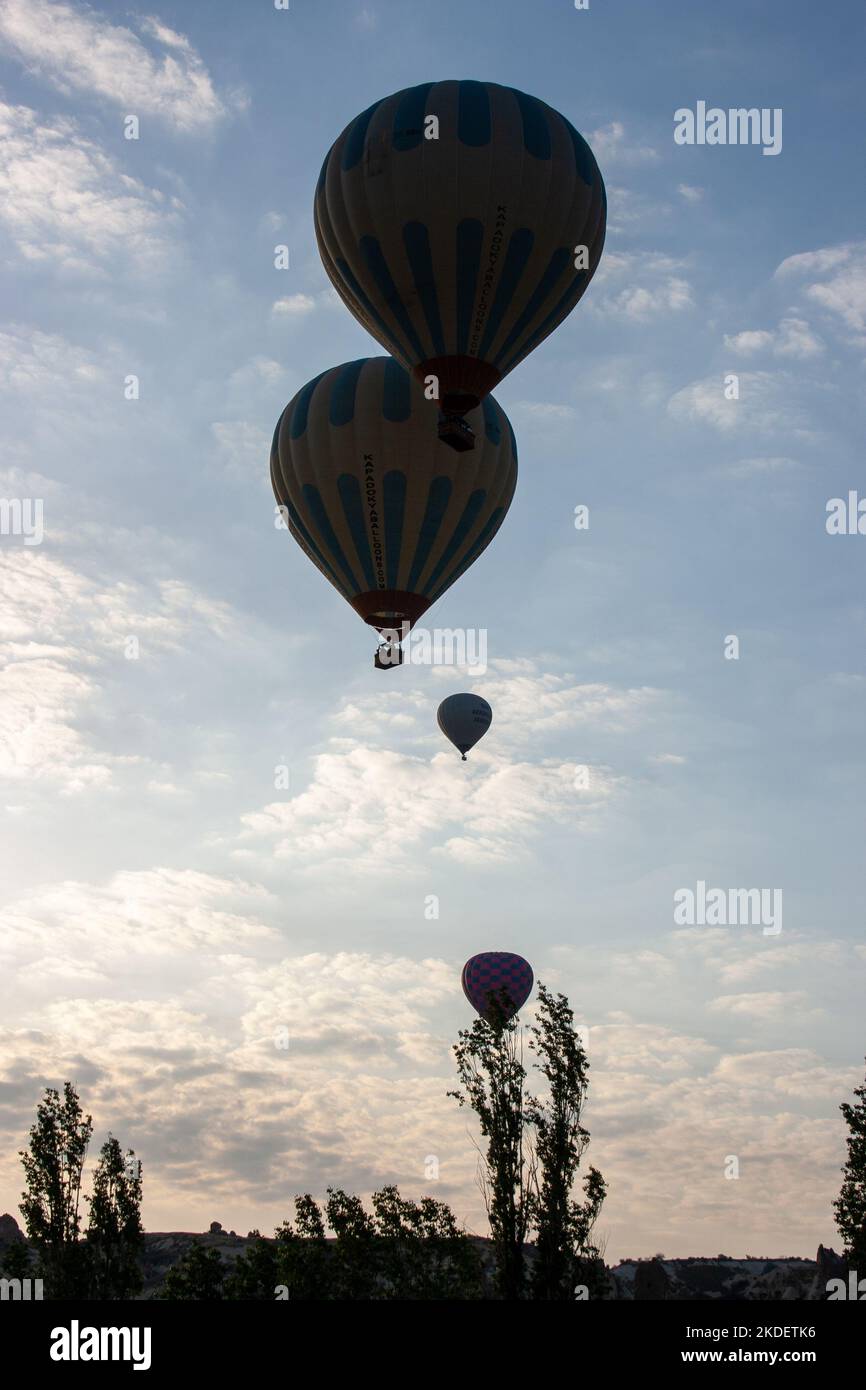 hot air balloons rise over the chimneys rock formation, Cappadocia ...