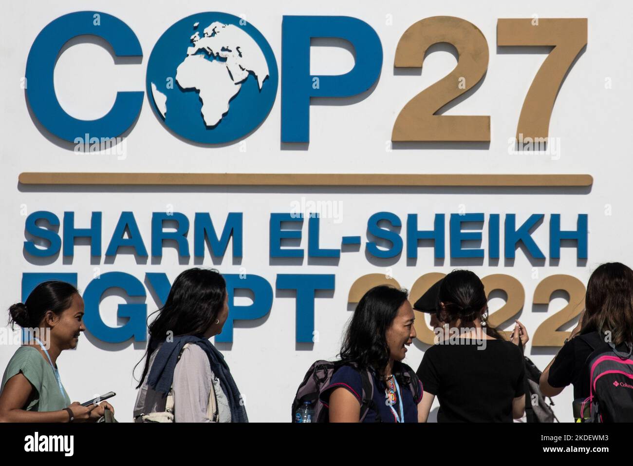 Sharm El Sheikh, Egypt. 06th Nov, 2022. Attendees stand in front of the logo of the 2022 United ...