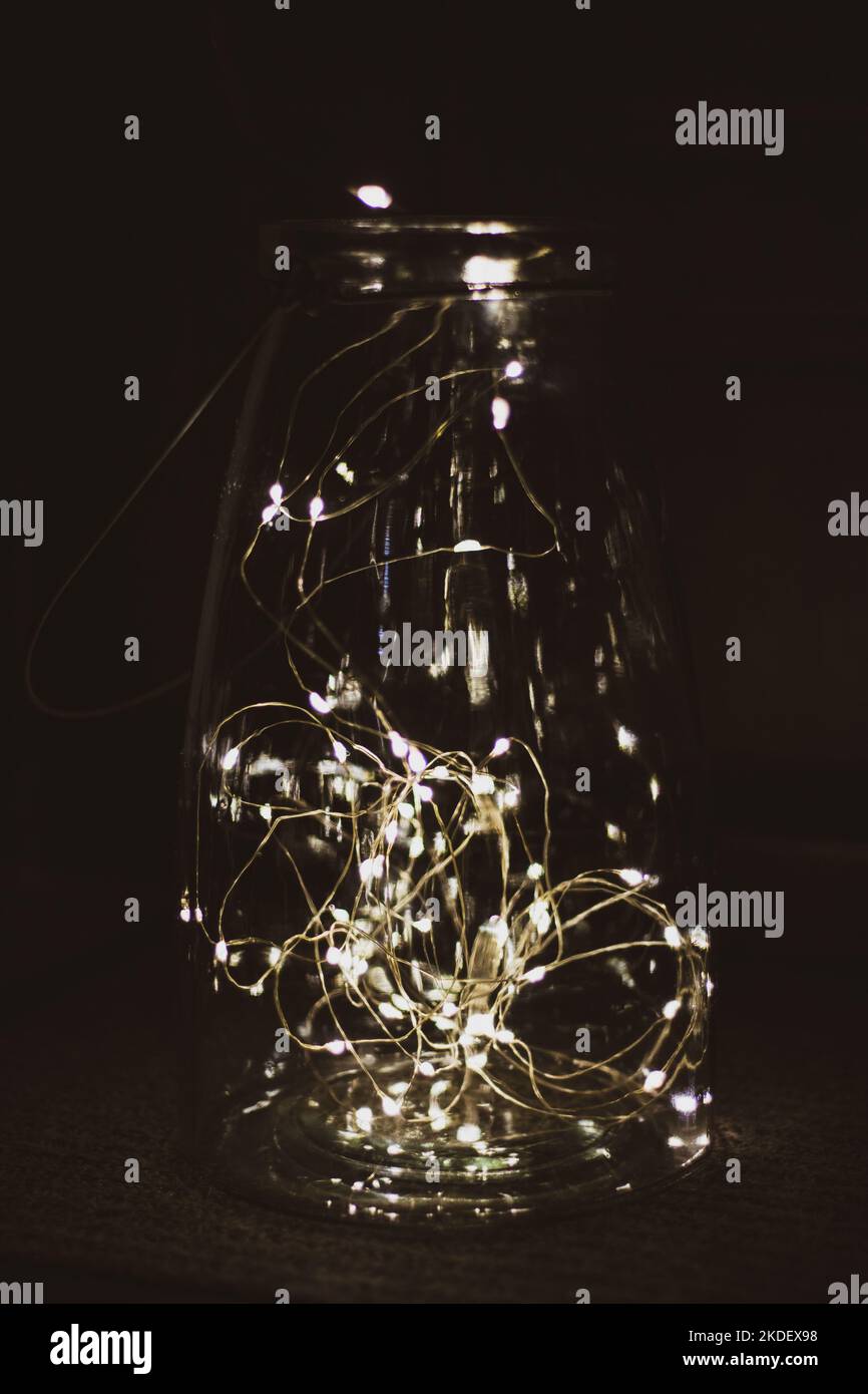 Electric garland in jar in night. Electricity economy. LED illumination ...