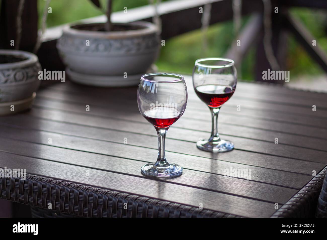 Two glasses of red wine in wooden table. Elegant wine party. Alcoholic ...