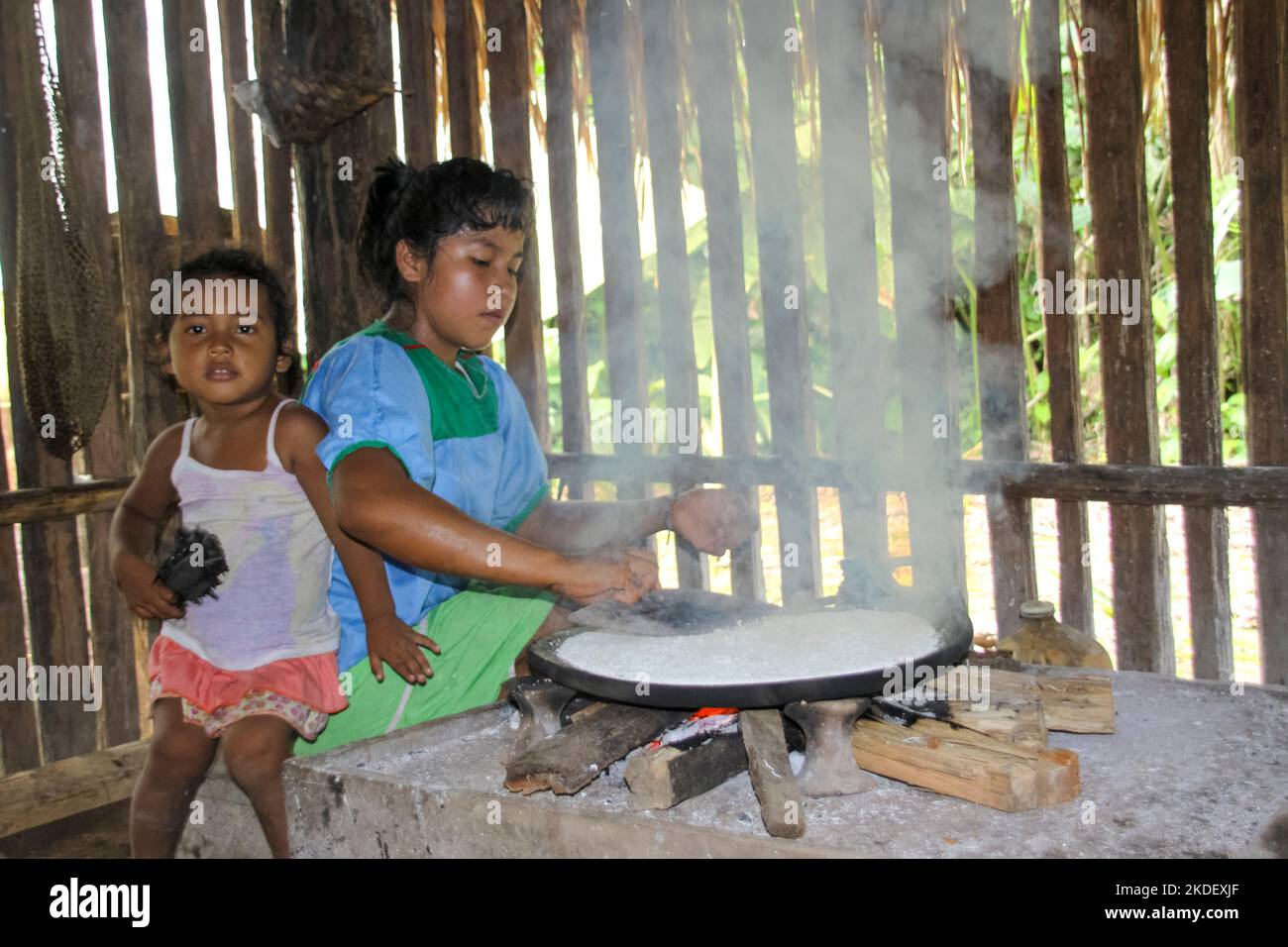 Woman demonstrates preparing and cooking yucca root tortillas in an ...