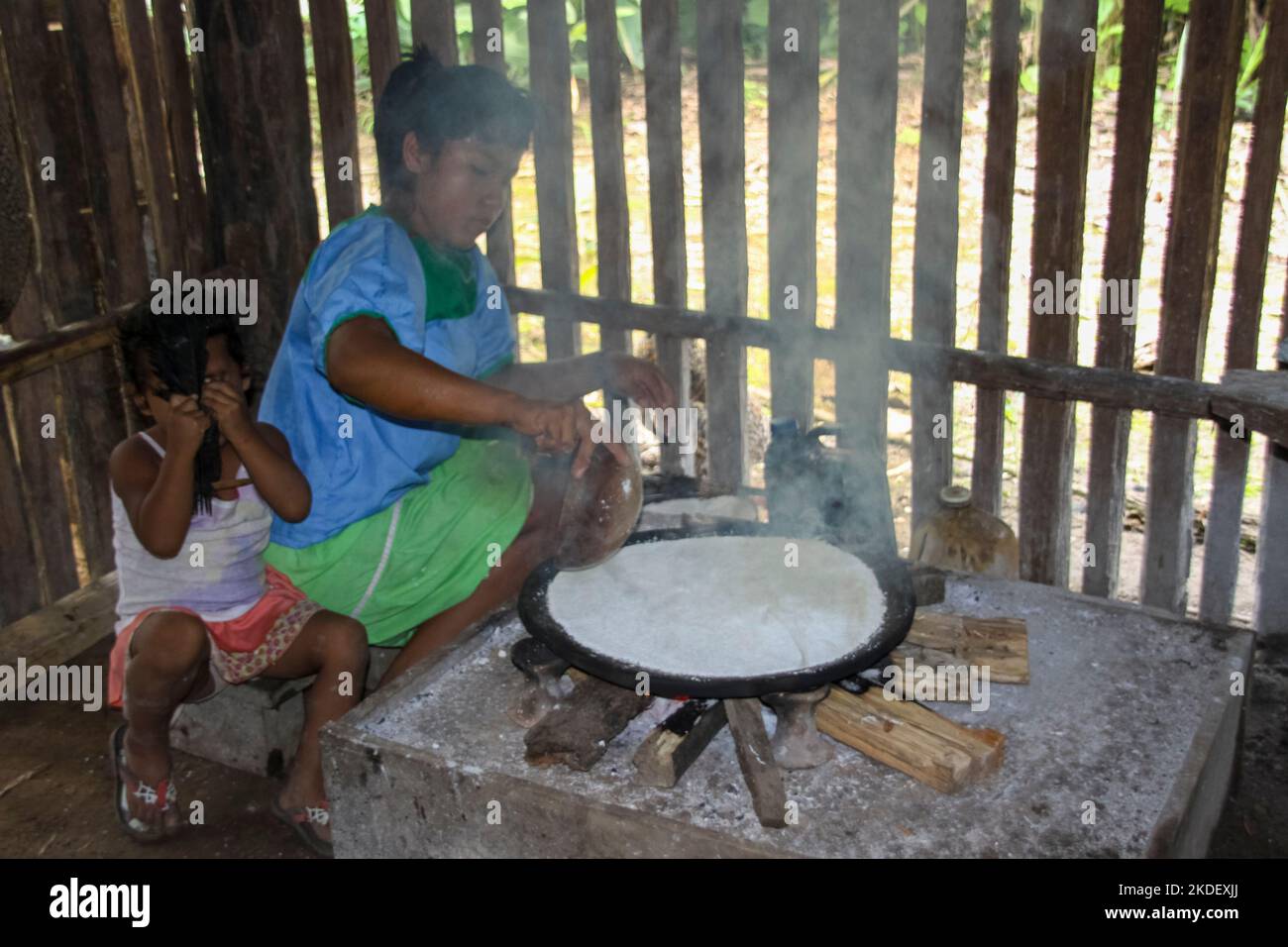 Woman demonstrates preparing and cooking yucca root tortillas in an ...
