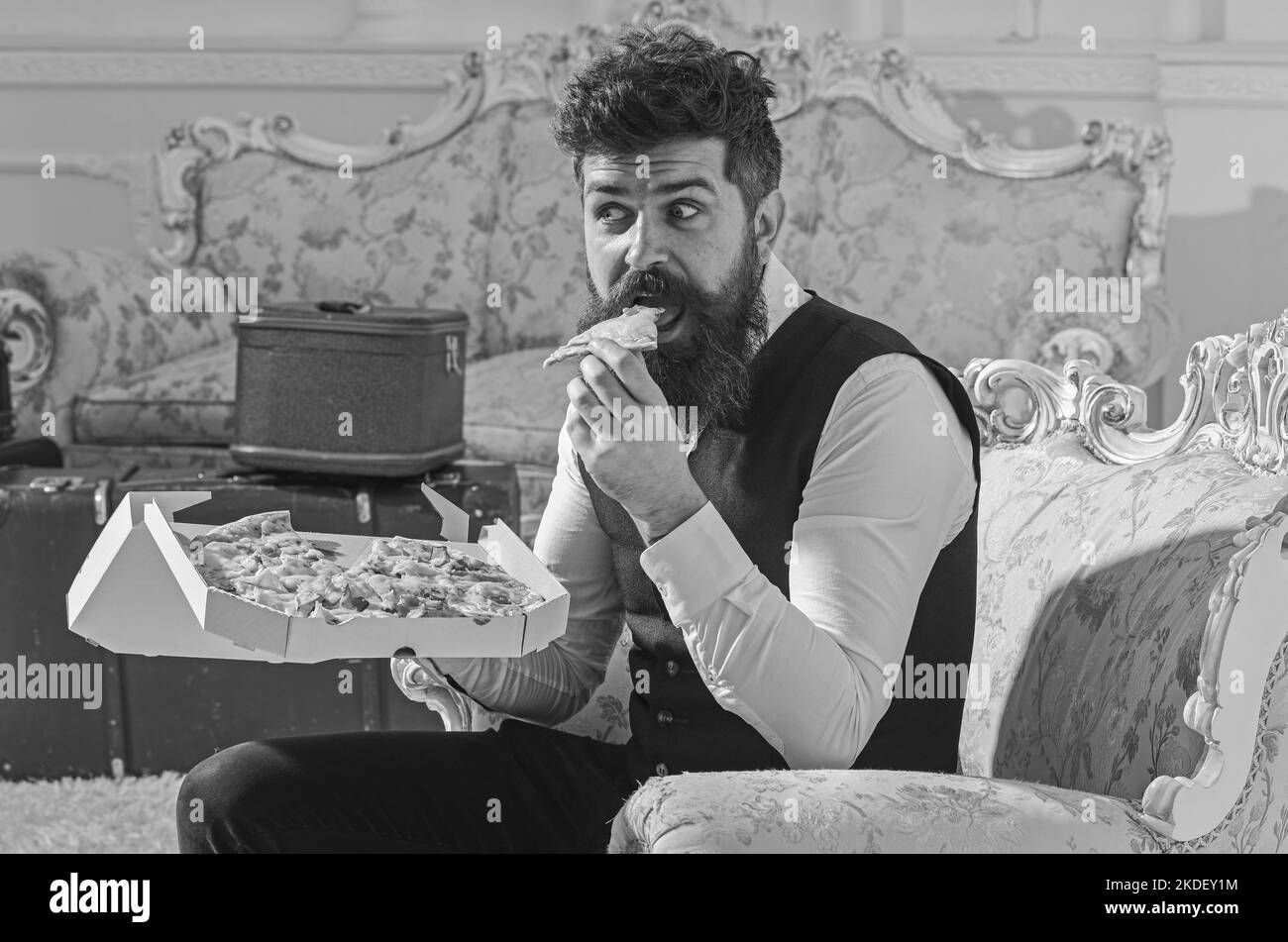 Macho in classic clothes hungry, on surprised face, bites slice of ...