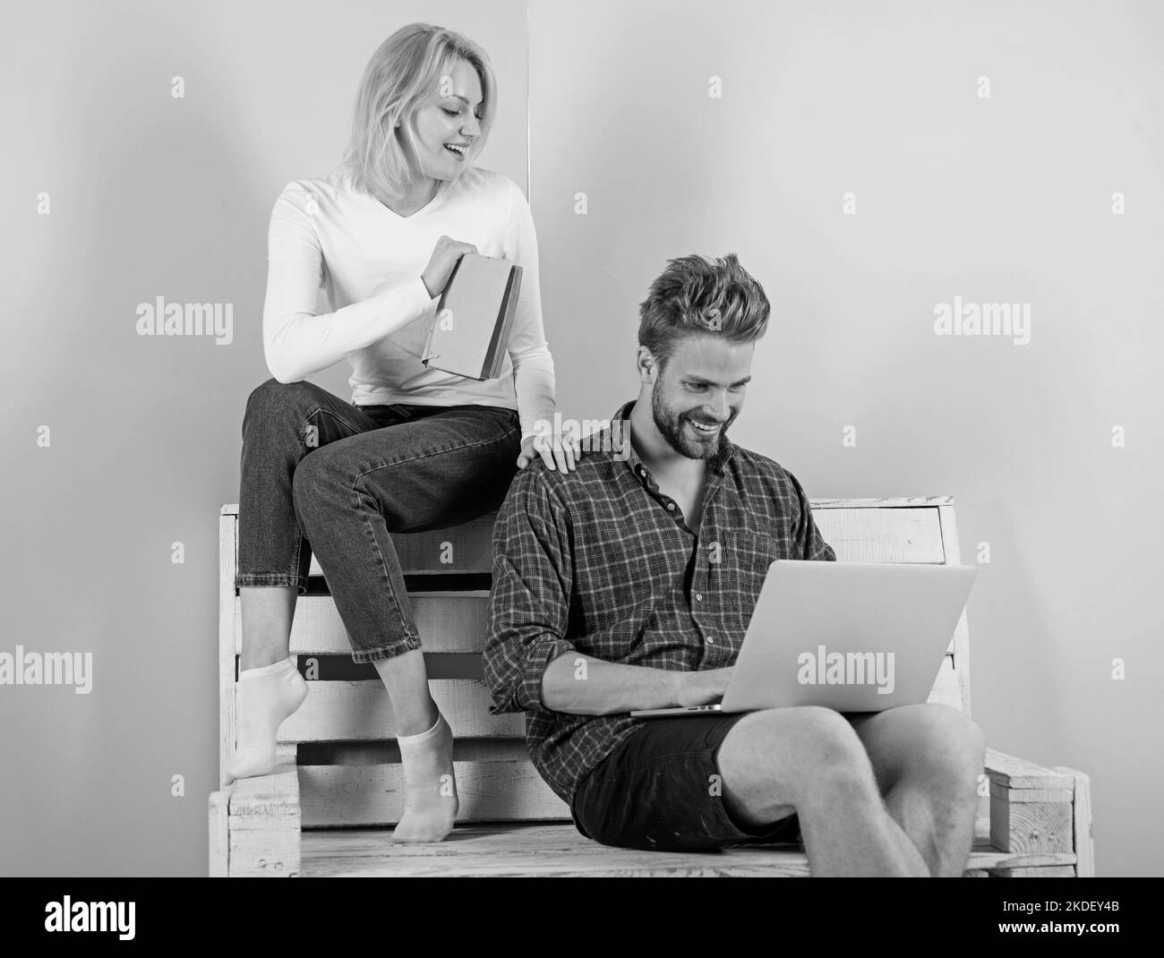 Couple students with book and laptop studying. Modern students use ...