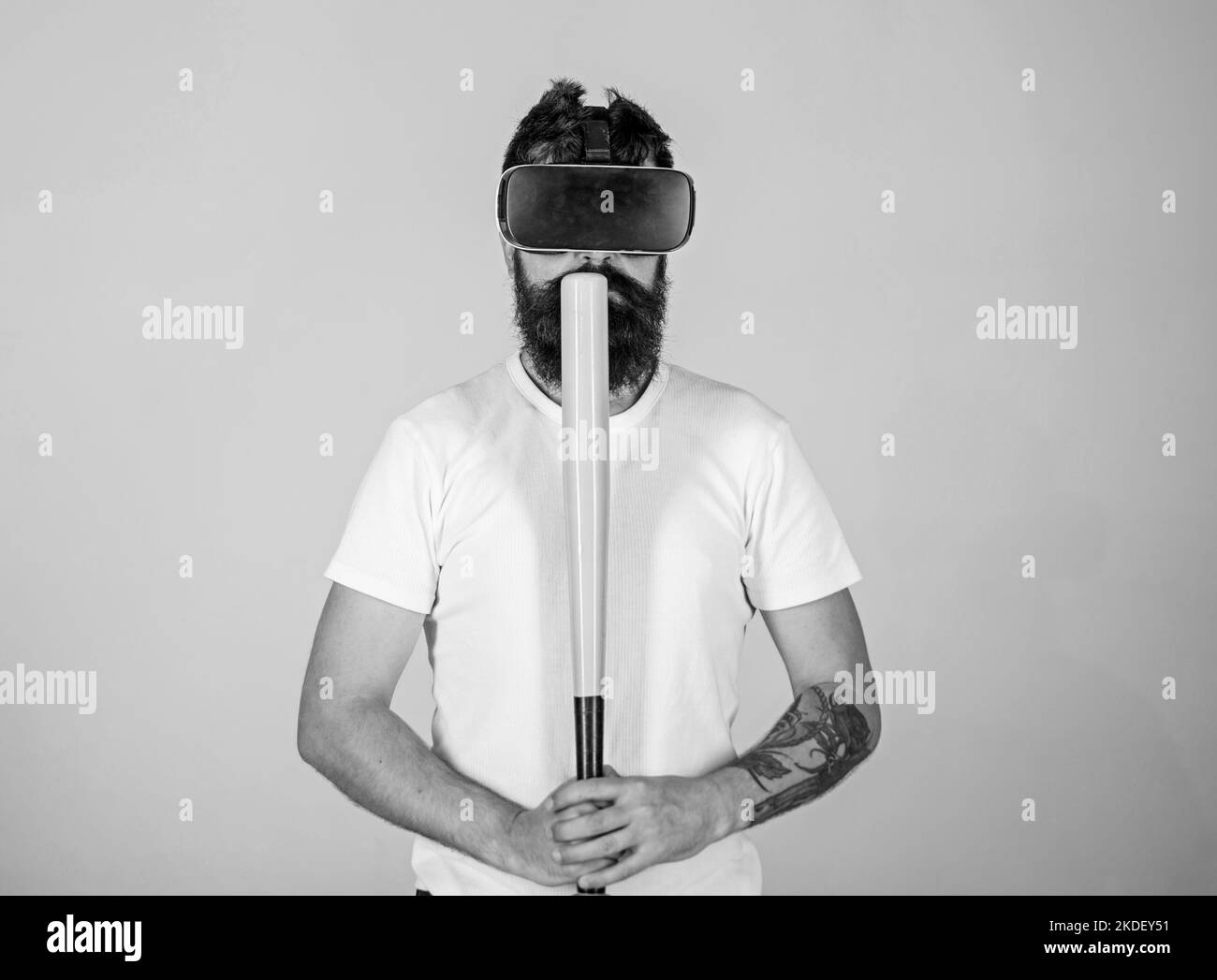 Man with beard in VR glasses, grey background. VR sportsman concept ...