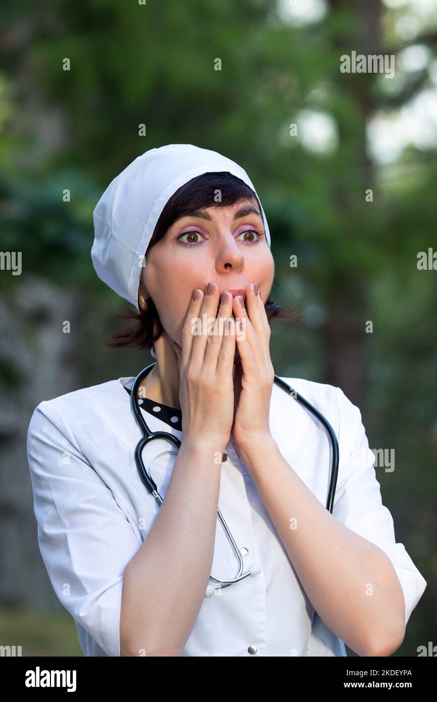 female doctor in a white coat screams fear after seeing something ...
