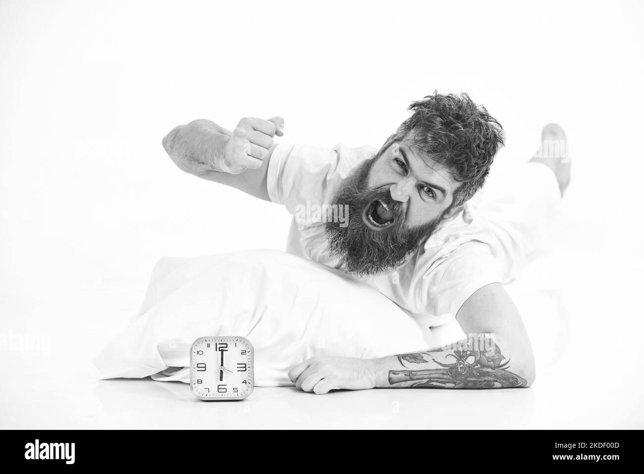 Guy with furious face beats alarm clock Stock Photo - Alamy