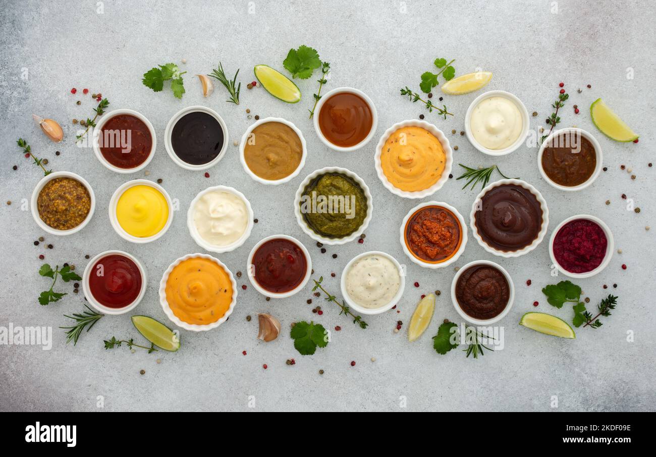 Different types of sauces in bowls with seasonings, rosemary and pepper ...