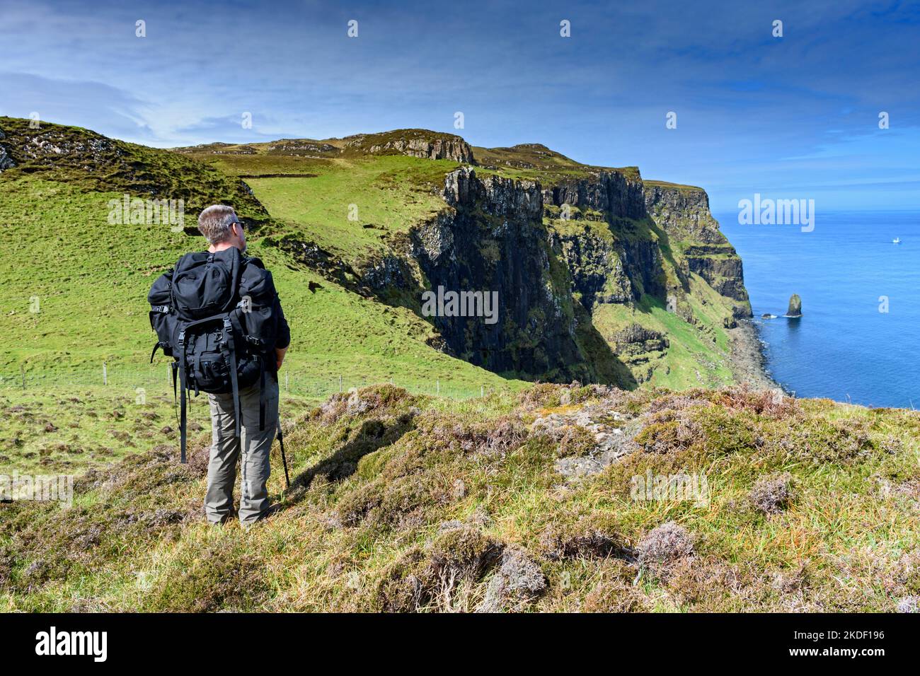 A walker on Compass Hill looking at the cliffs along the north coast of ...