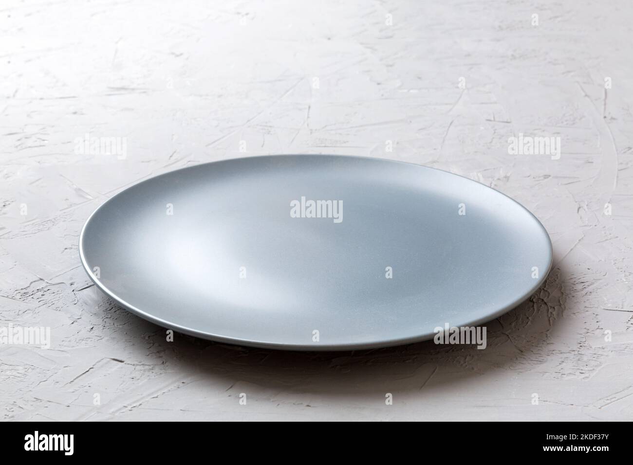 Perspective view of empty grey plate on cement background. Empty space ...