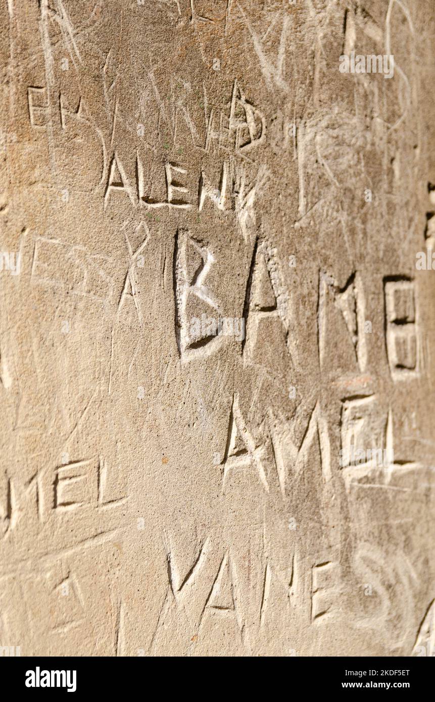 Wall with writing on it. Damaged with various signatures carved in its ...