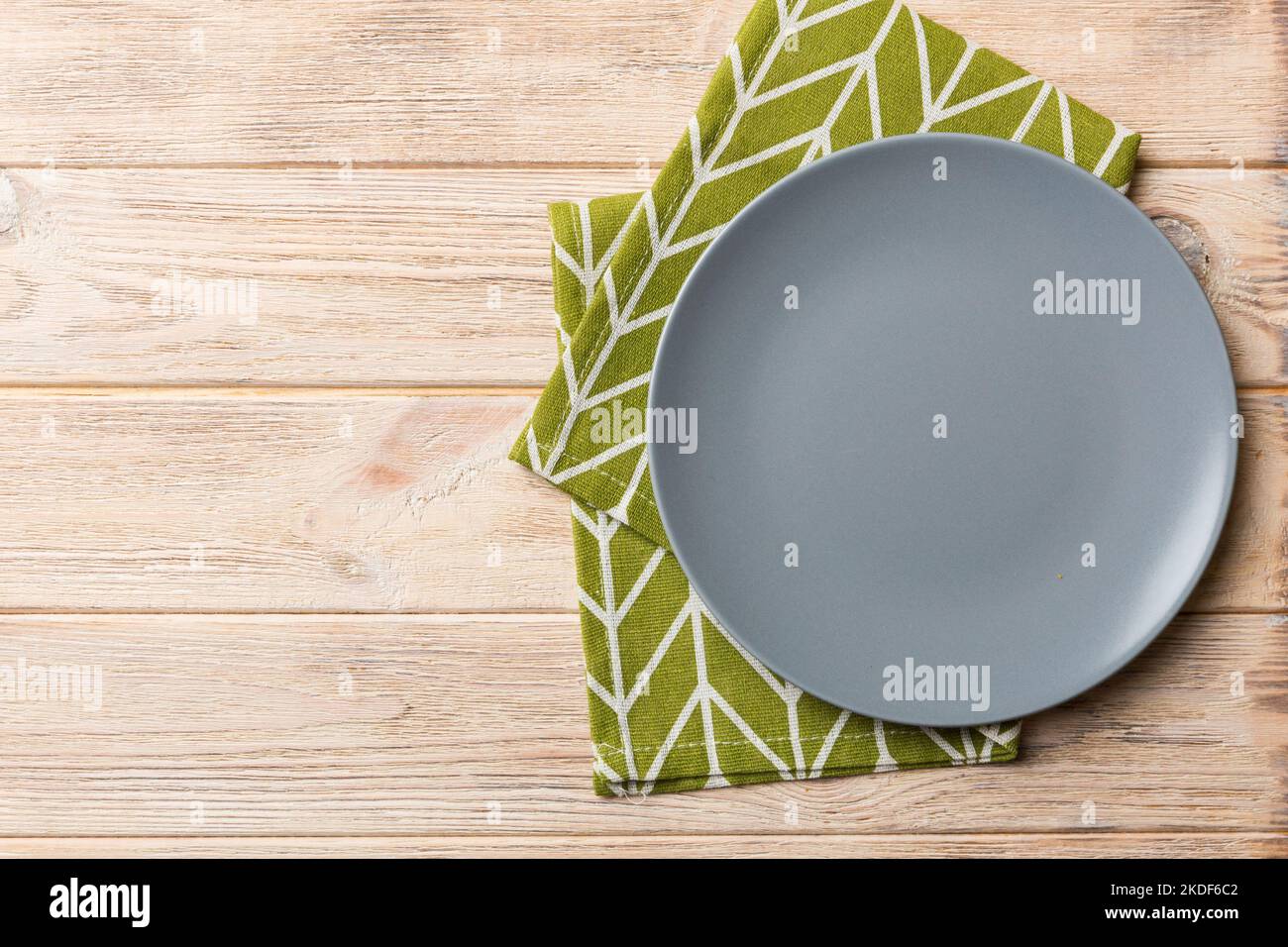 Top view on colored background empty round gray plate on tablecloth for ...