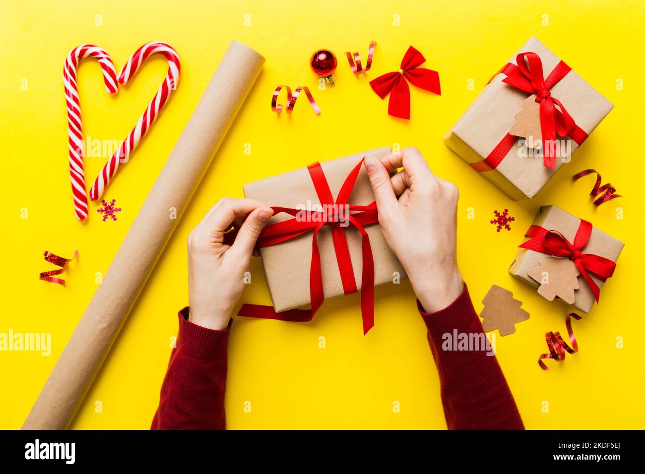 Woman is packing surprise gift for Christmas holidays, sitting at ...
