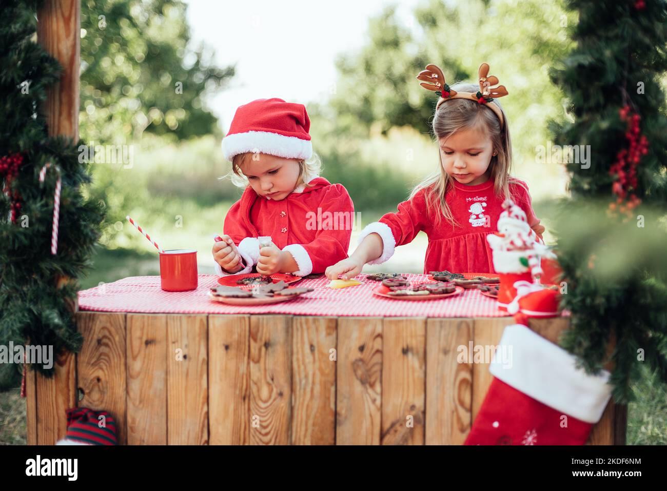 Happy children preparing for Christmas. Two girls in santa hat coloring ...