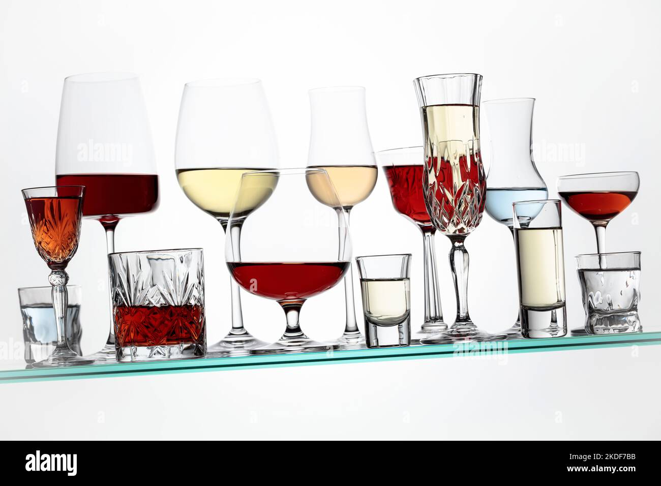 Various alcoholic drinks in a bar on a tilted glass shelf Stock Photo ...