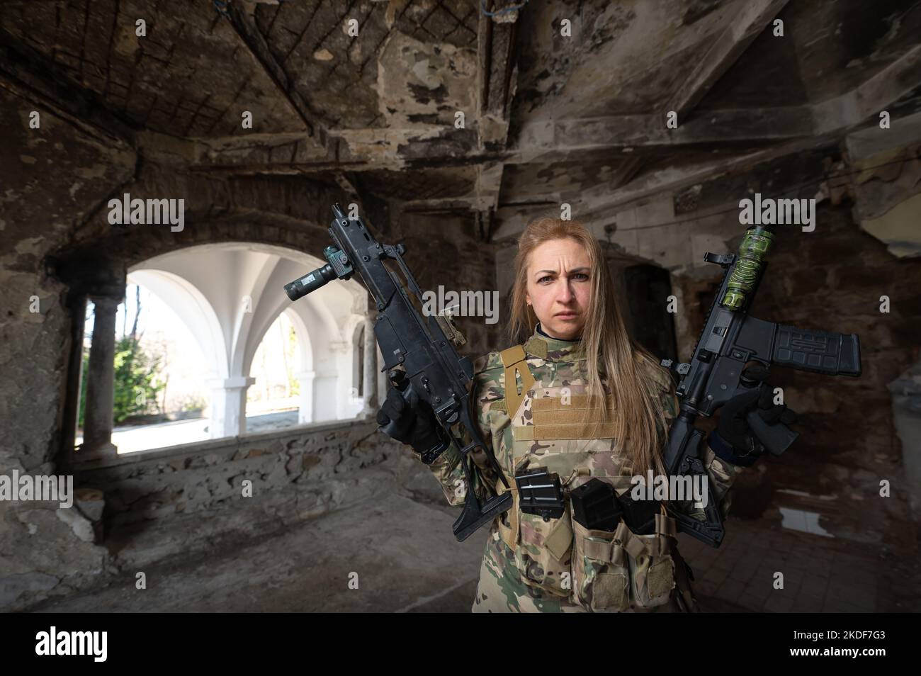 Caucasian woman in army uniform holding two machine guns Stock Photo ...
