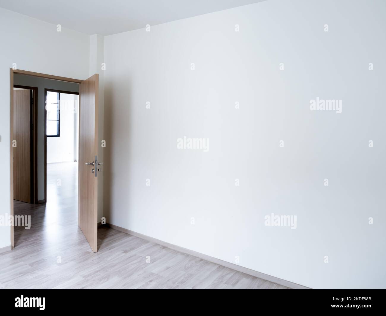 Blank white wall background in the empty room near the wooden opened ...